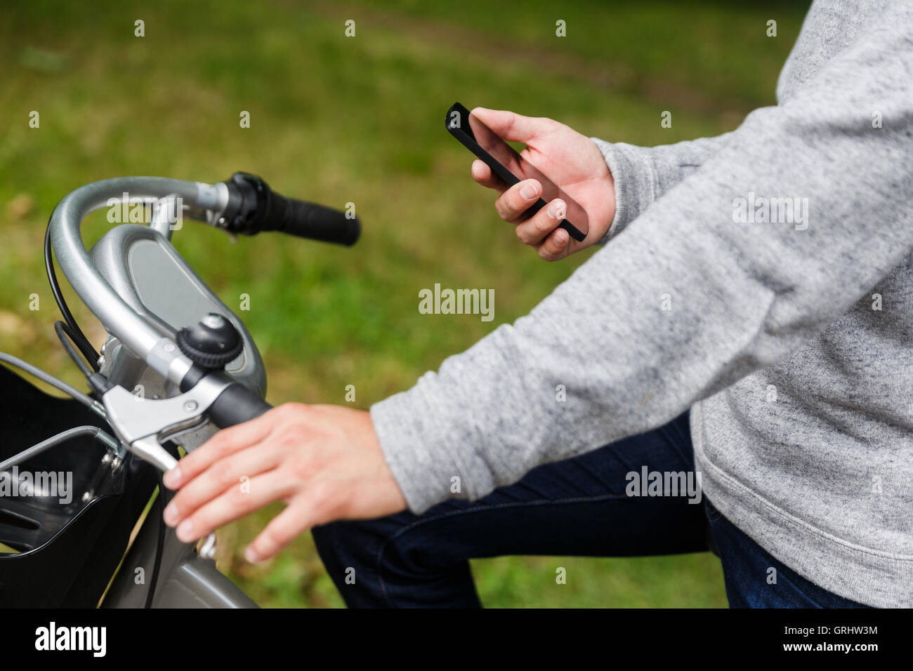 Male figure on the bike with smartphone Stock Photo - Alamy