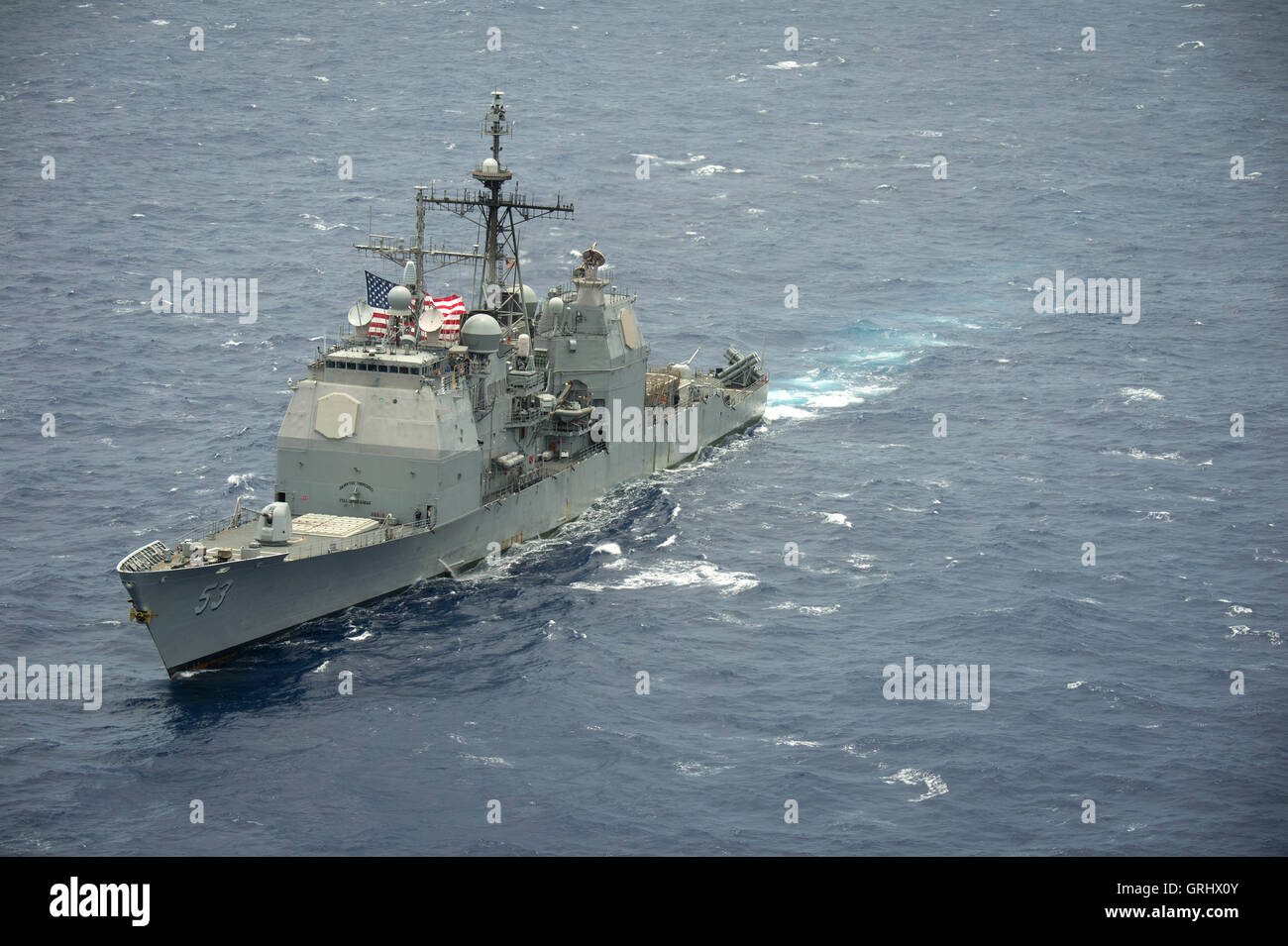U.S. Navy guided-missile cruiser USS Mobile Bay steams in close ...