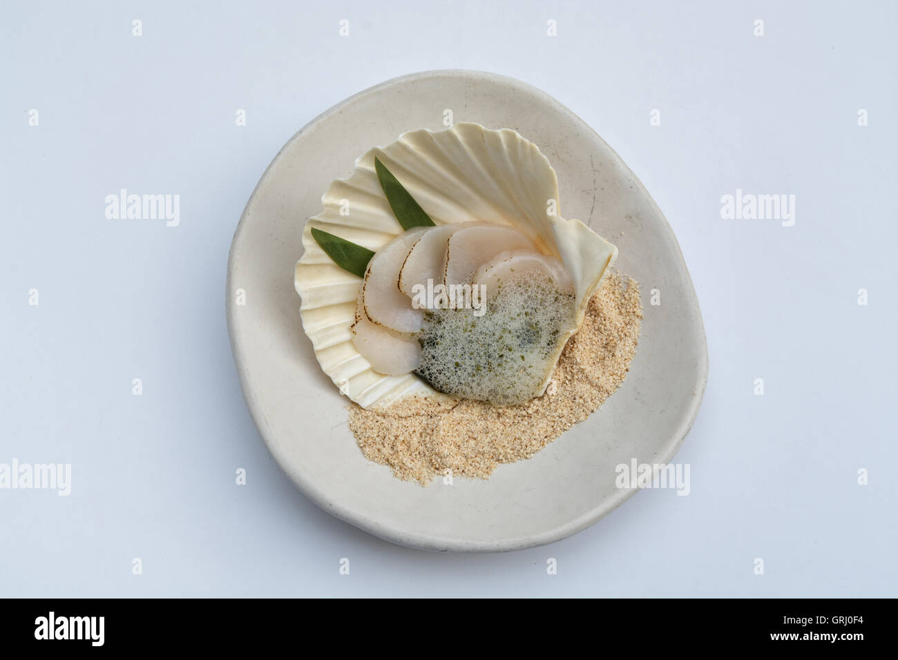 shellfish clams with sea foam reduction on sand made of bread Stock ...