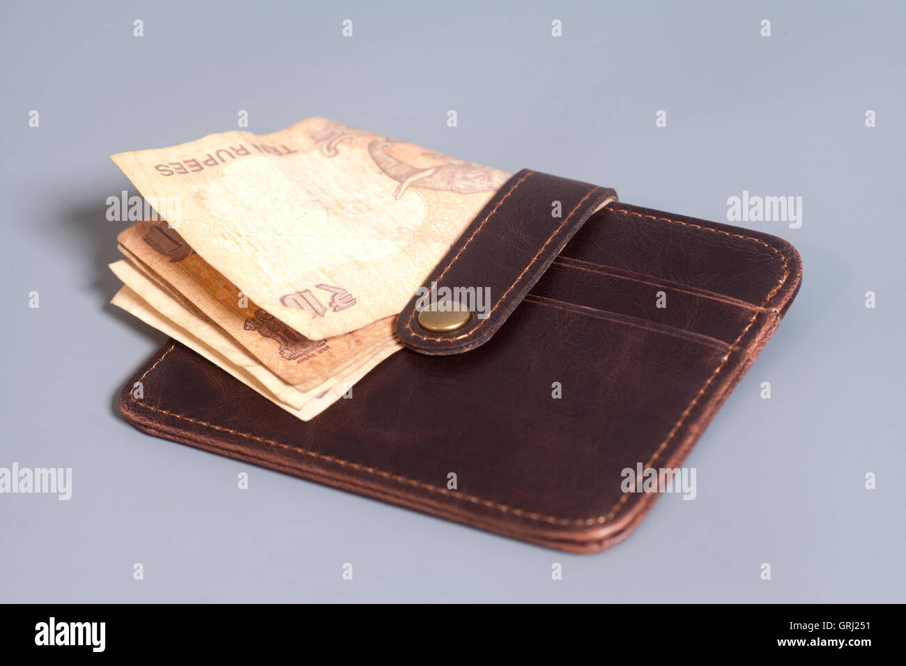 Brown leather wallet with Indian rupee currency on gray background ...