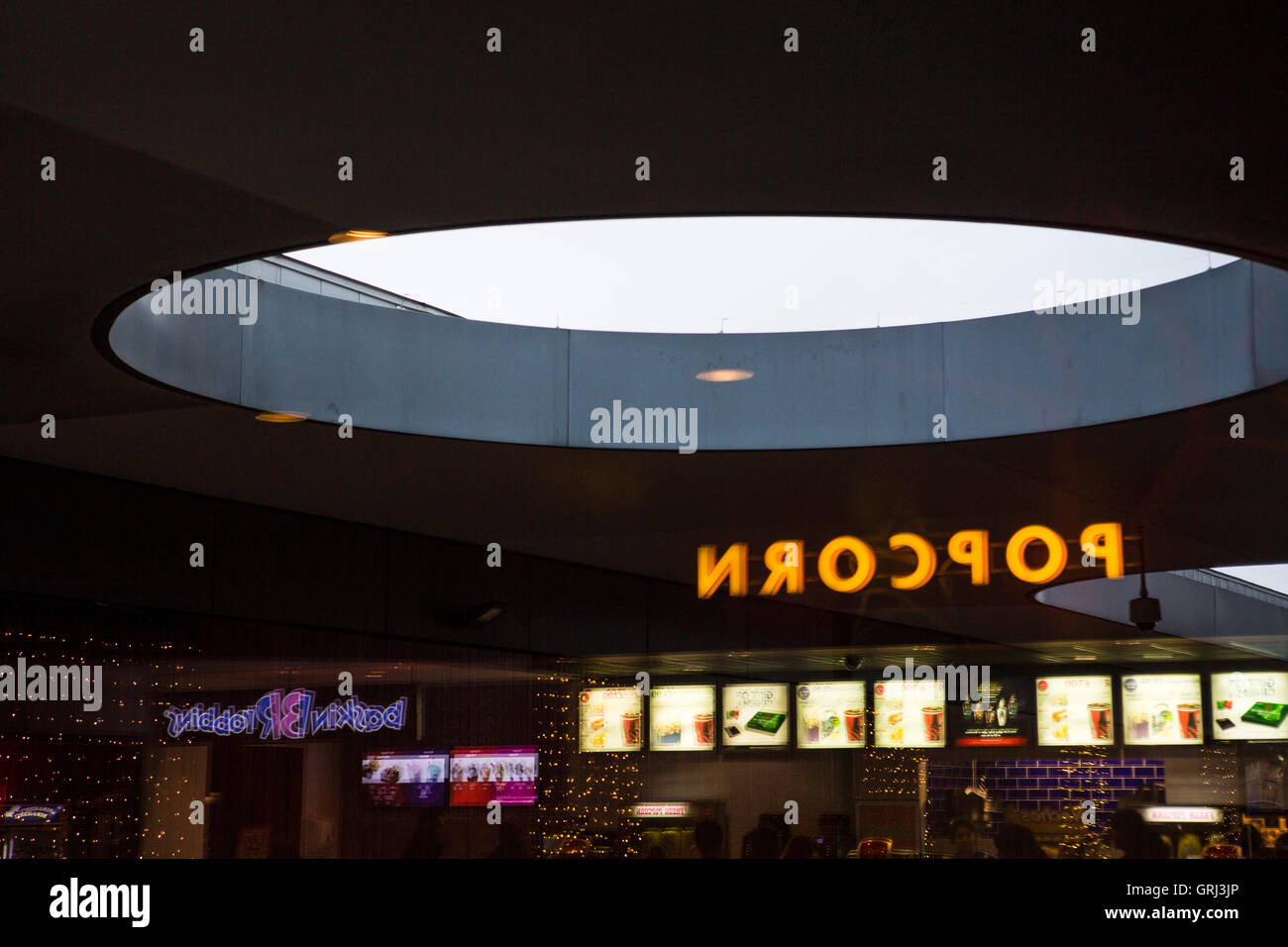 Illuminated popcorn sign and shop fronts with reflectiuons, inside ...