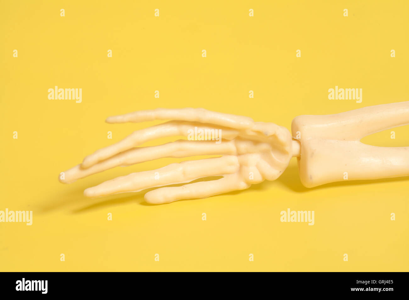 skeleton human hand on yellow background Stock Photo - Alamy