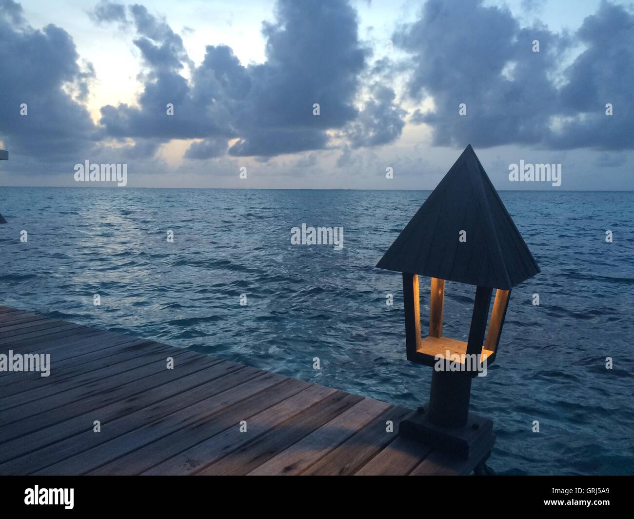 Dark cloudy horizon over indian ocean with decking and light in ...