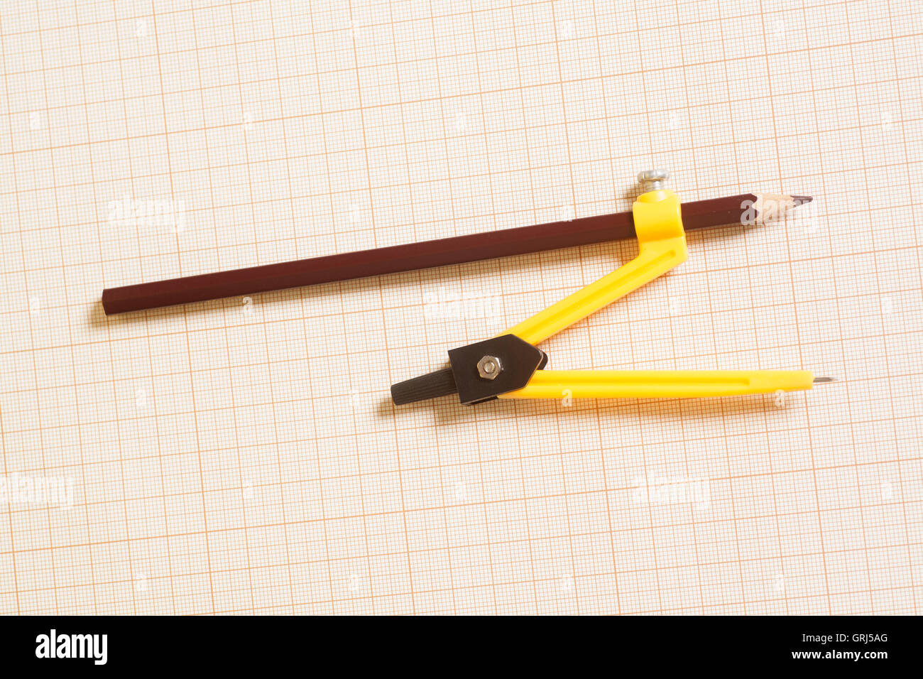 Yellow Drawing compass on graph paper Stock Photo - Alamy