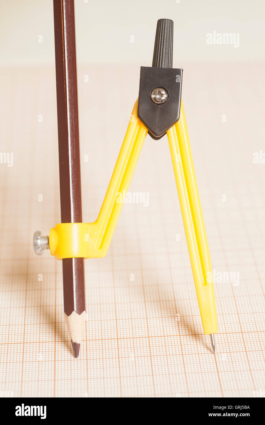 Yellow Drawing compass on graph paper Stock Photo - Alamy