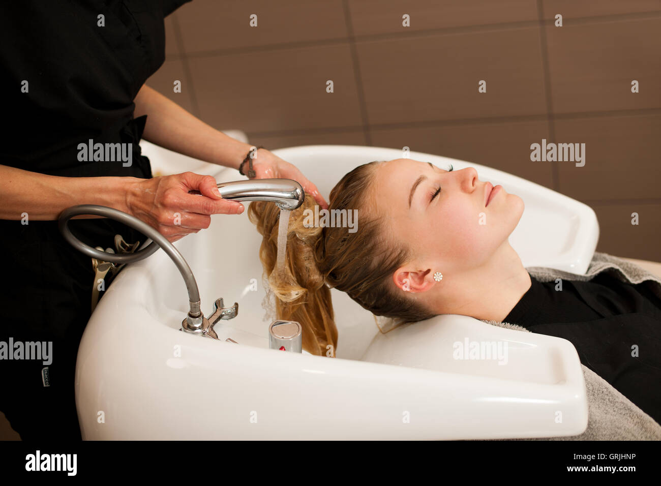 Hair stylist at work - hairdresser washing hair to the customer before ...