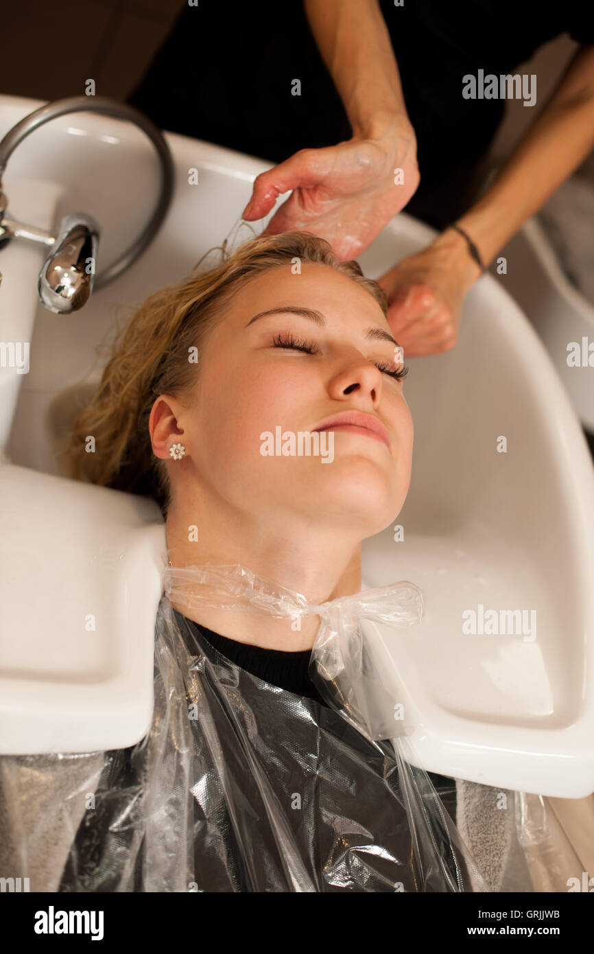 Hair stylist at work - hairdresser washing hair to the customer before ...