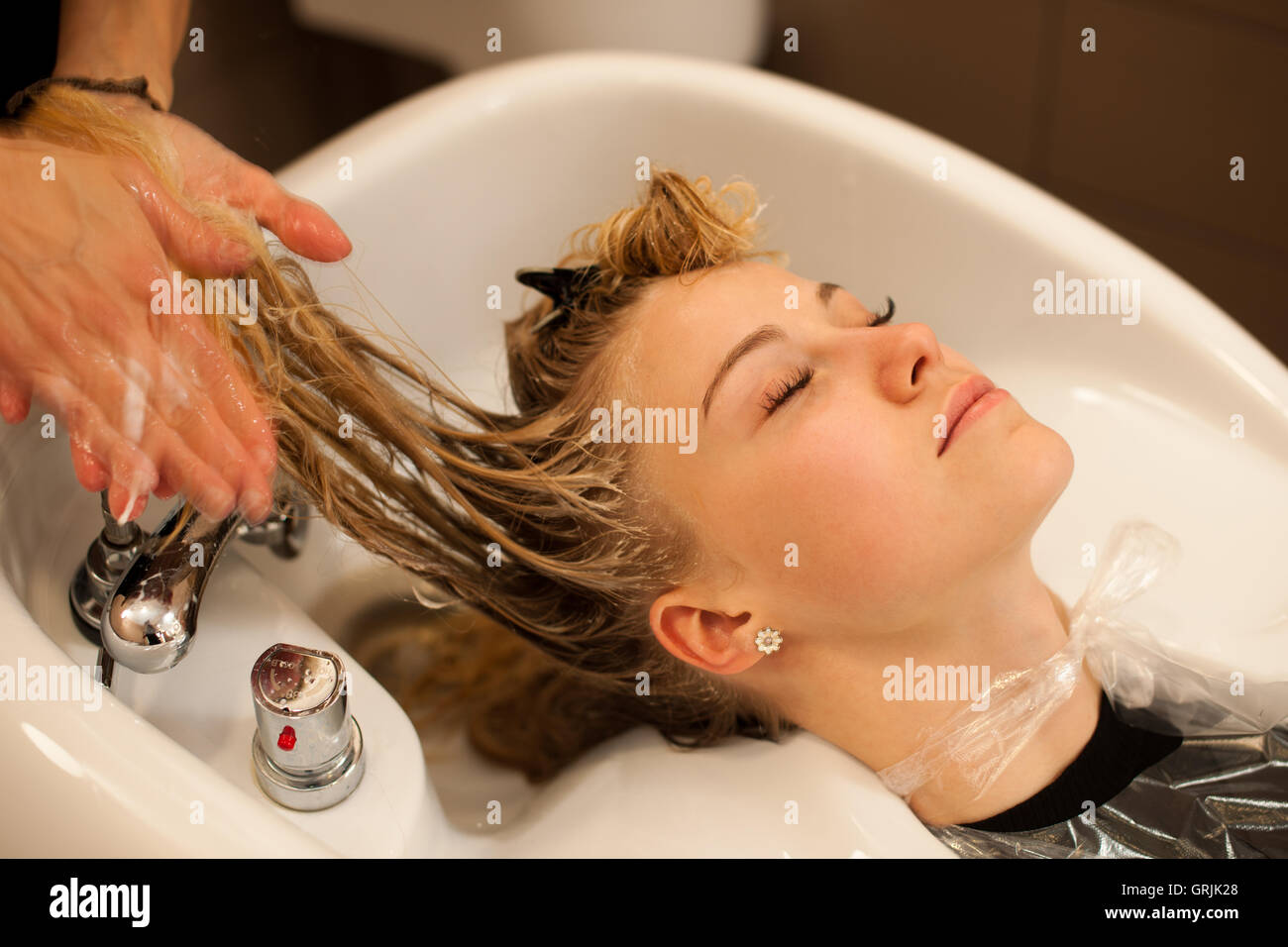 Hair stylist at work - hairdresser washing hair to the customer before ...