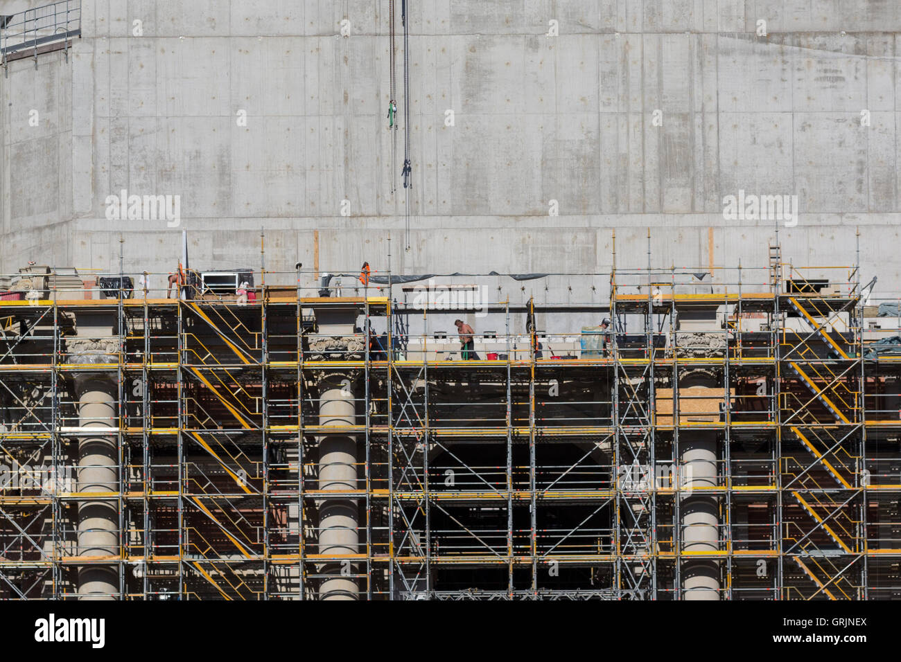 Construction worker on scaffolding rebuilding facade of city palace ...