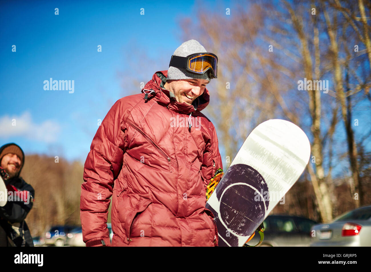 A snowboarder walking with his board Stock Photo - Alamy