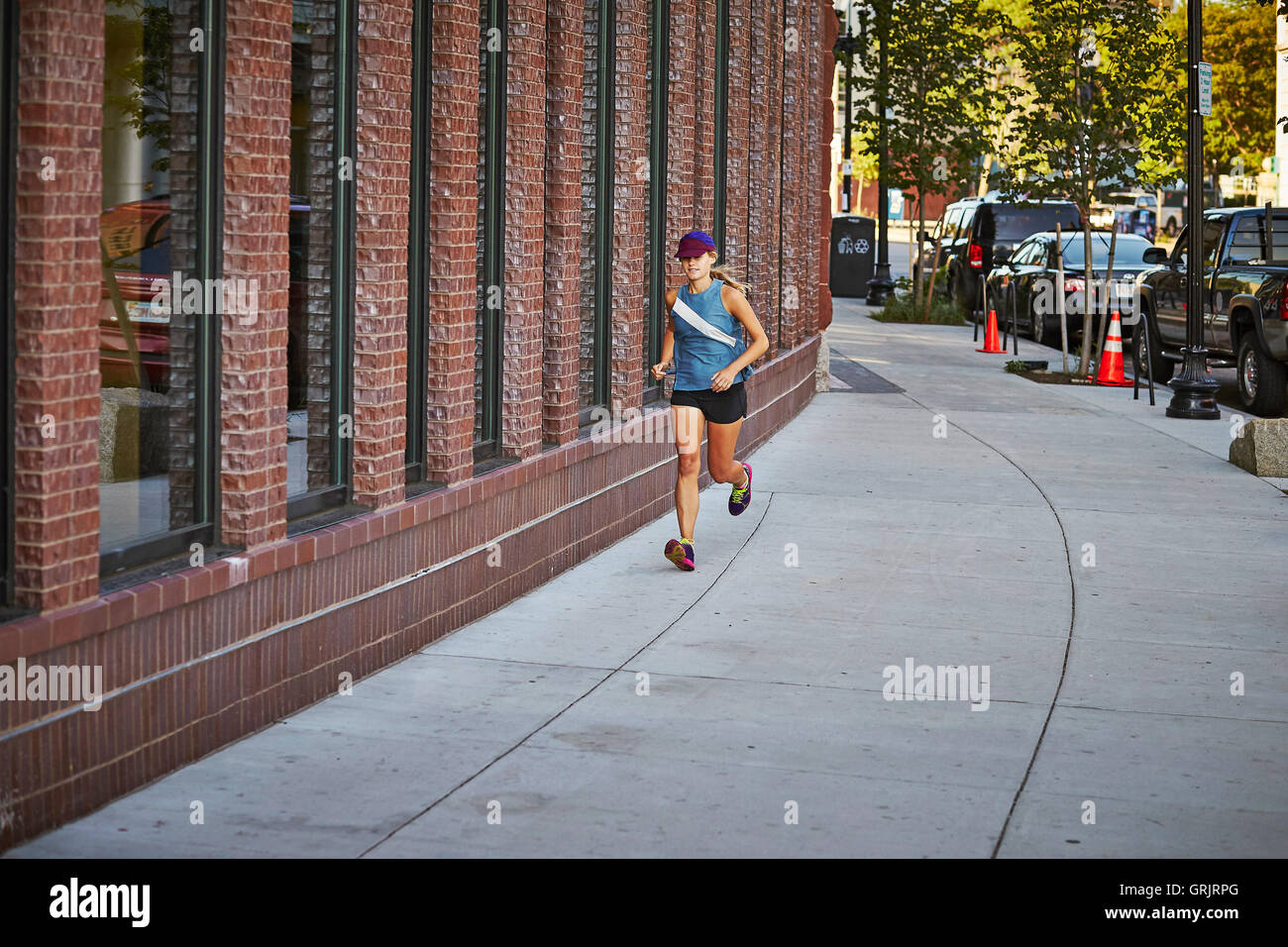 A female runner running through the city Stock Photo - Alamy