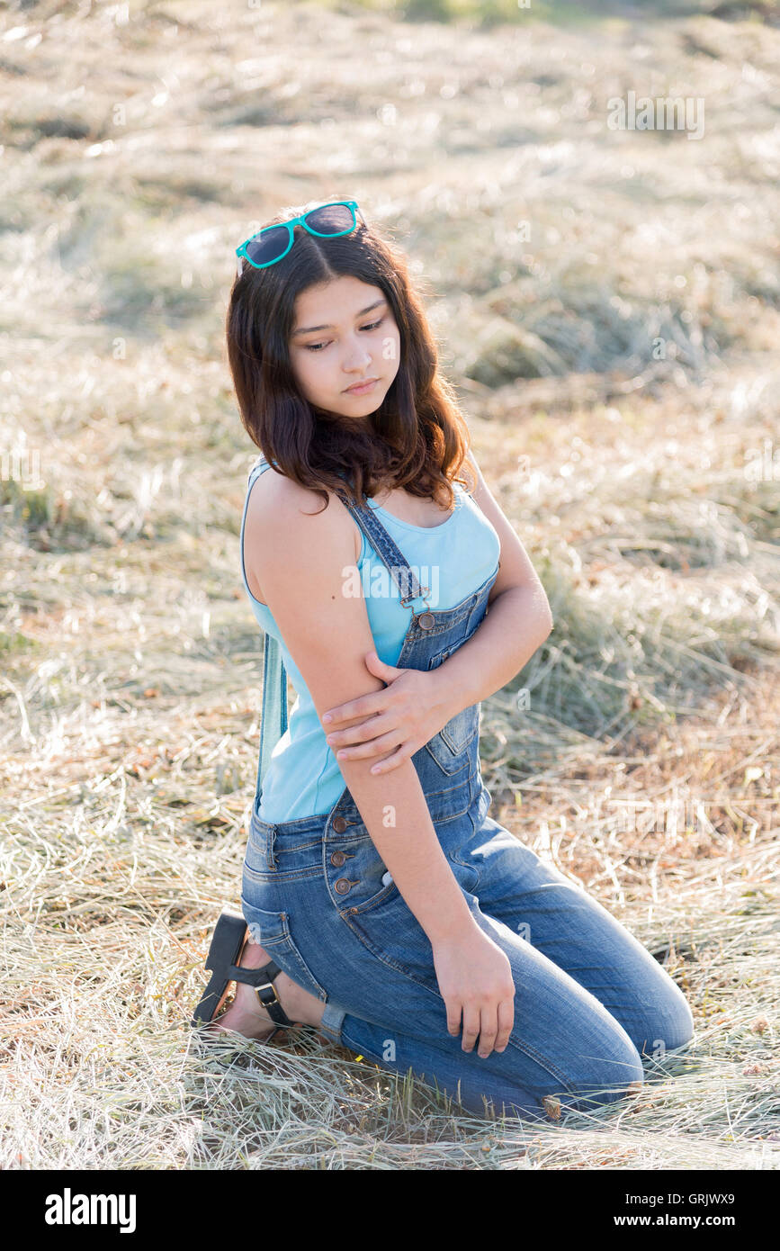 Girl posing on field with straw Stock Photo - Alamy