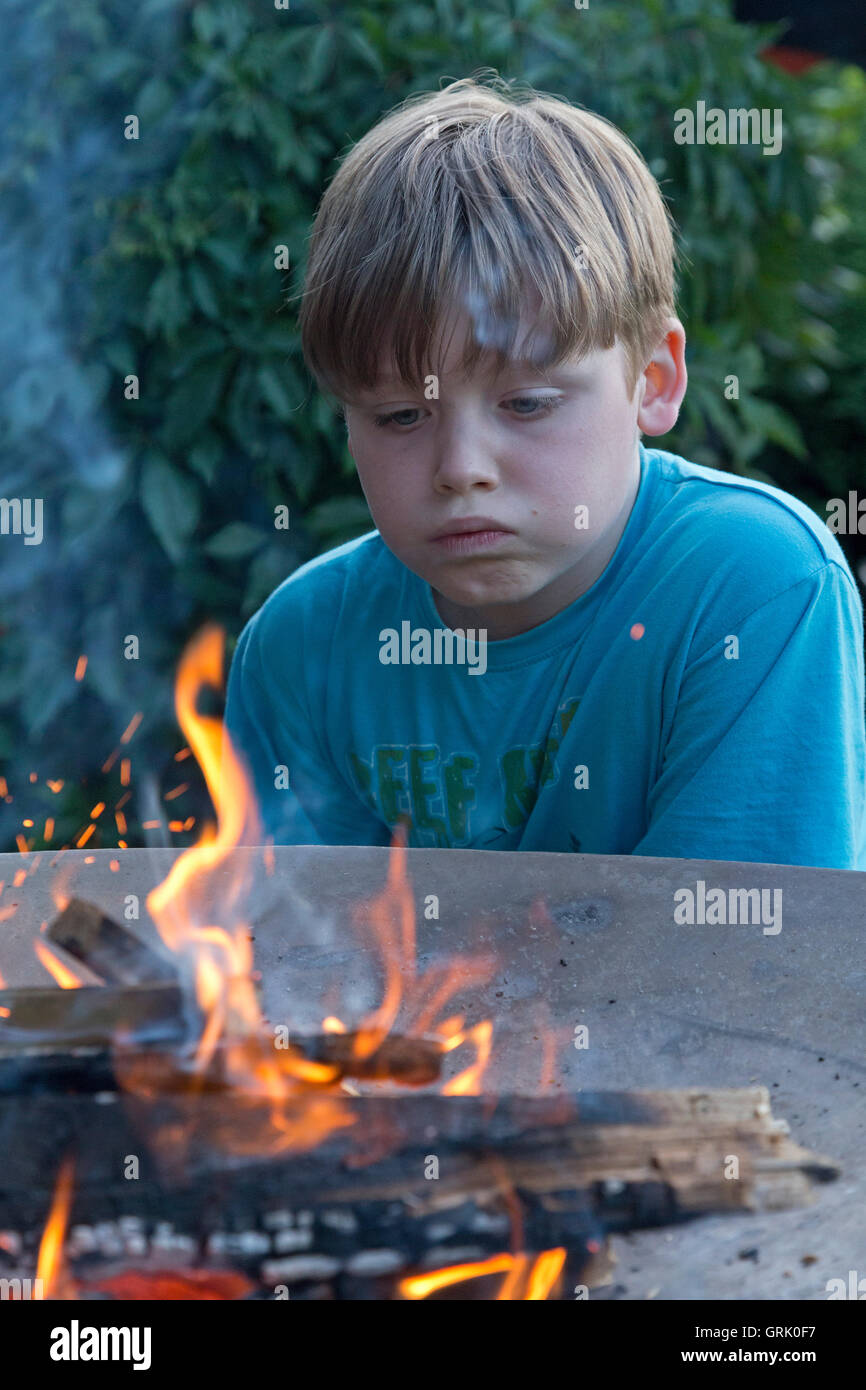 young boy keeping fire alive by blowing Stock Photo - Alamy