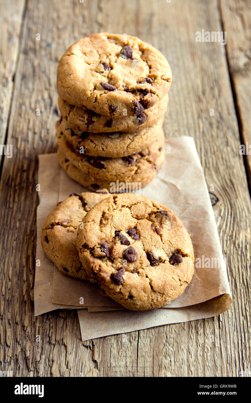 Chocolate chip cookies on paper and rustic wooden table Stock Photo - Alamy