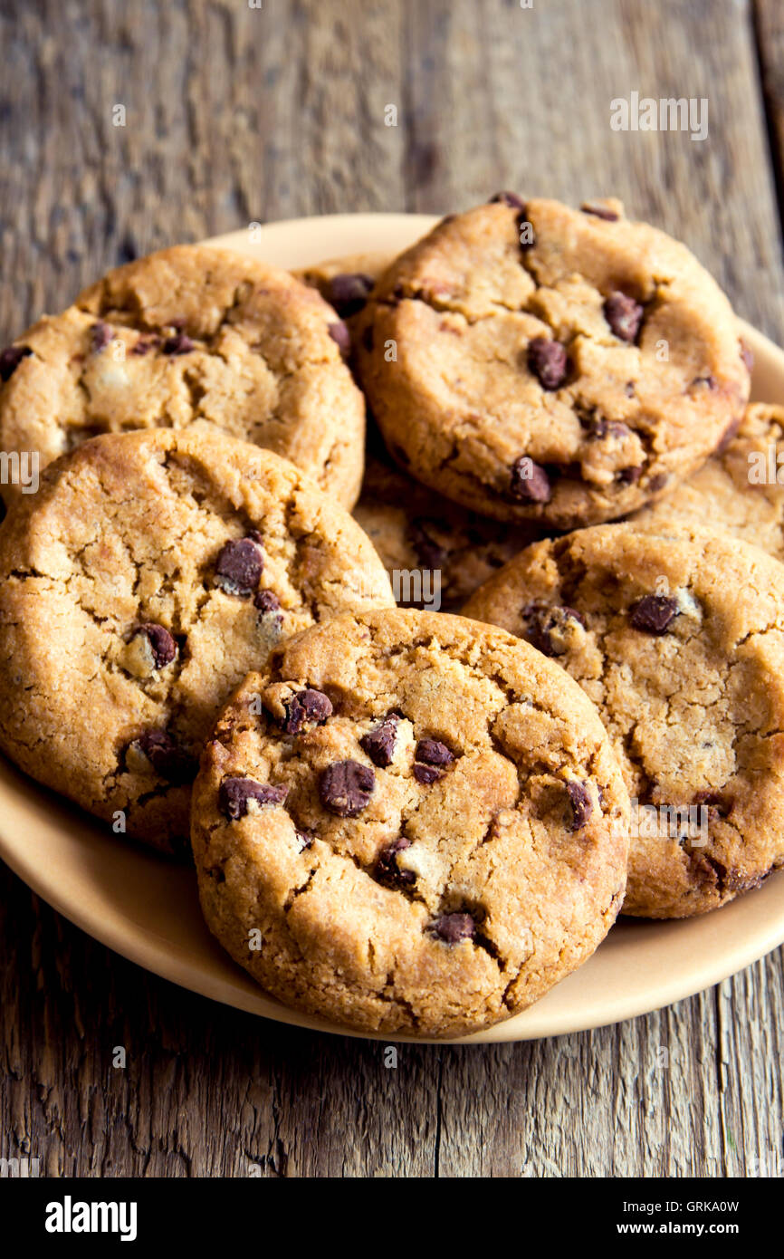 Chocolate chip cookies on plate and rustic wooden table Stock Photo - Alamy