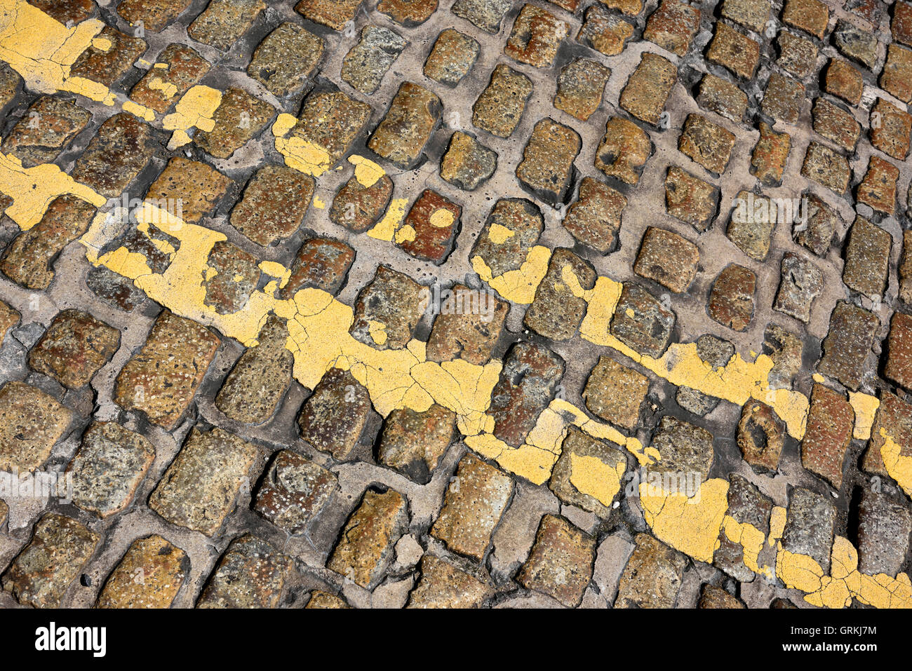 double yellow lines on cobble stones Stock Photo - Alamy