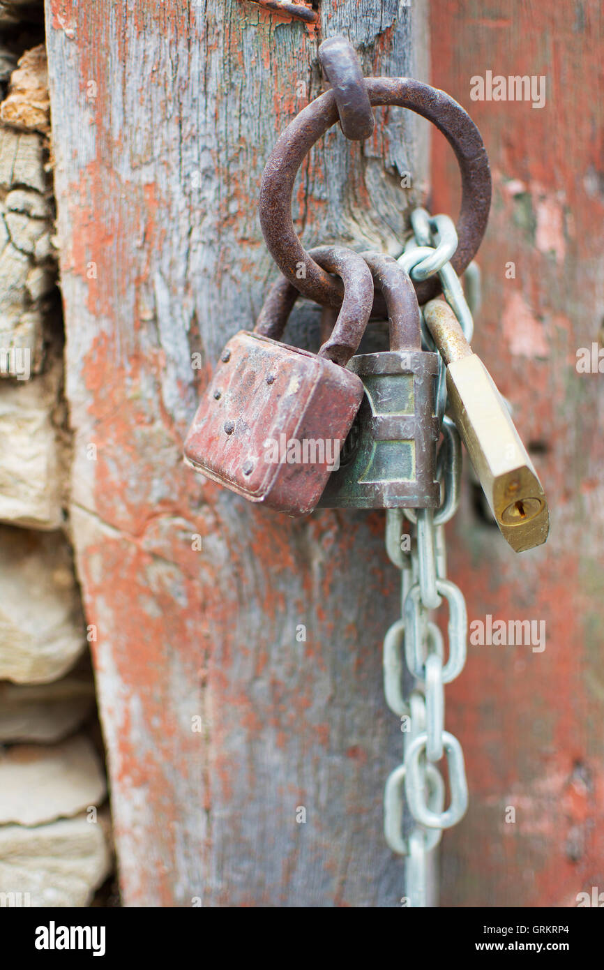 Vintage Corroded Padlocks with Chain on a Ancient Red Gate Background ...