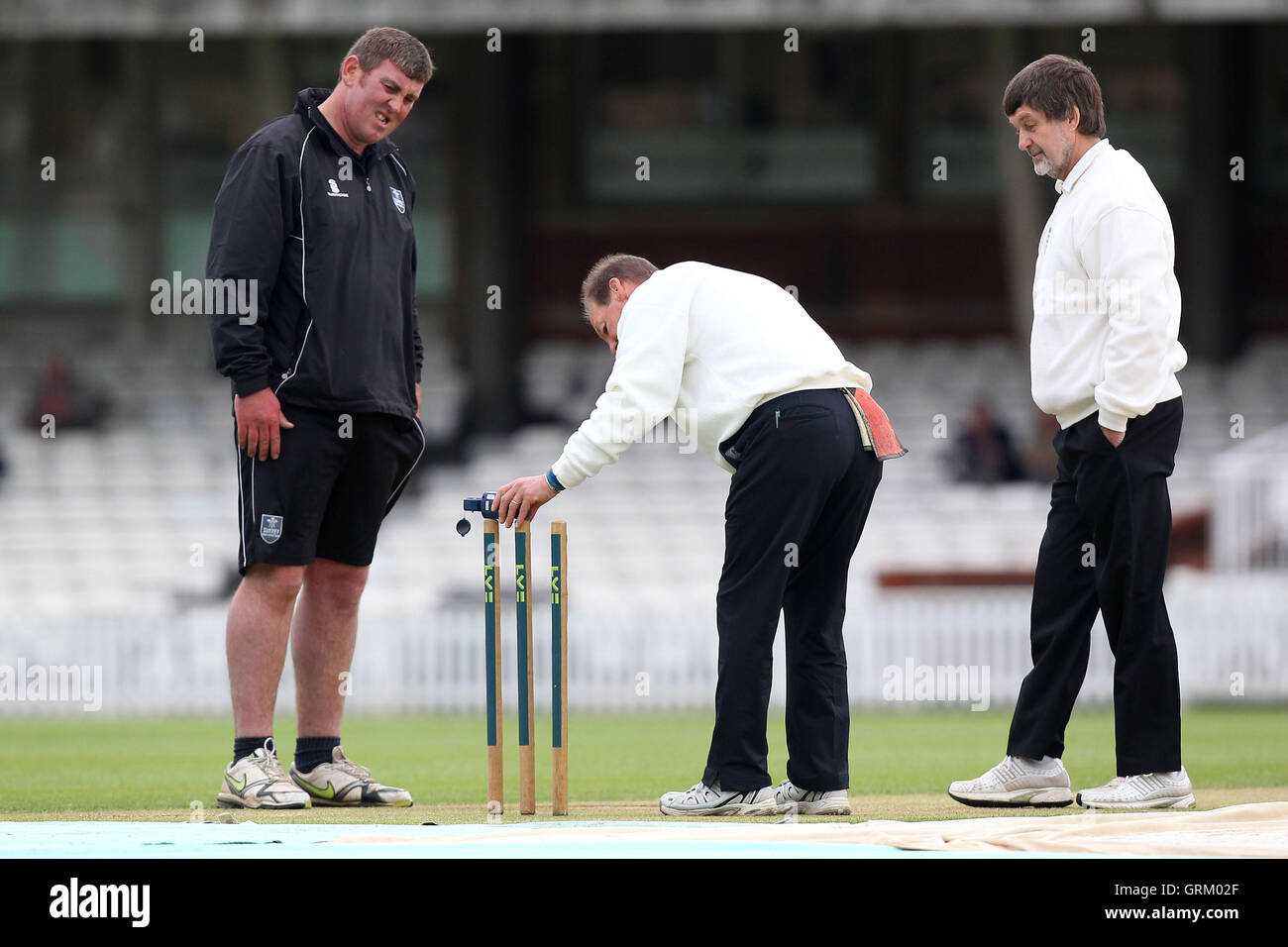 Umpires Peter Willey (R) and Jeremy Lloyds place a light meter on the ...
