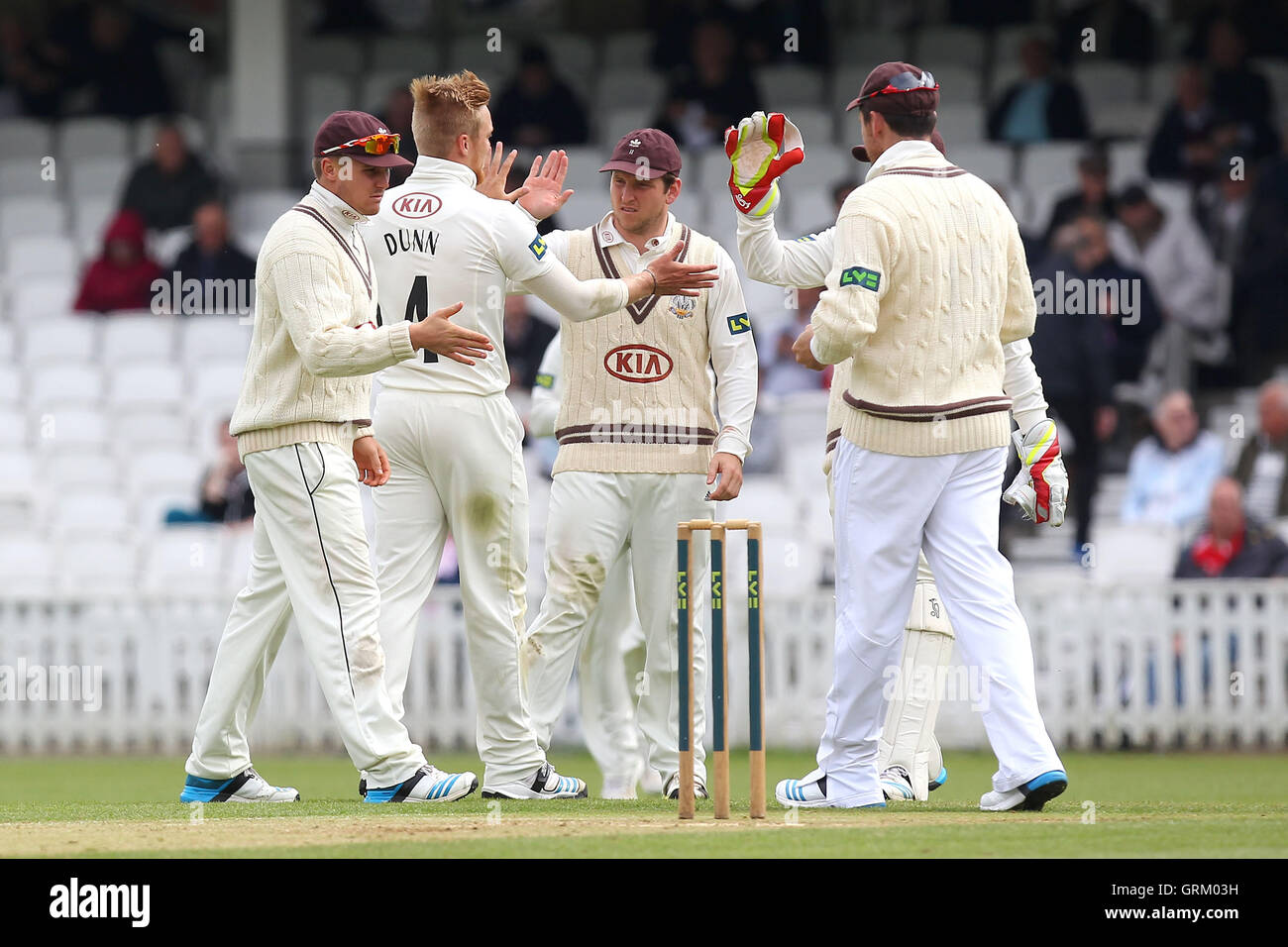 Matthew Dunn of Surrey is congratulated on the wicket of Graham Napier ...