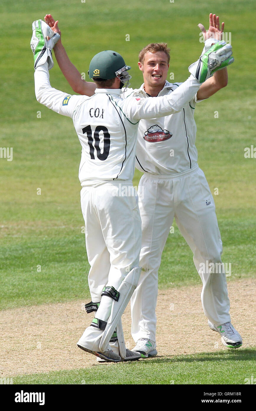 Charlie Morris of Worcestershire (R) is congratulated on the wicket of ...