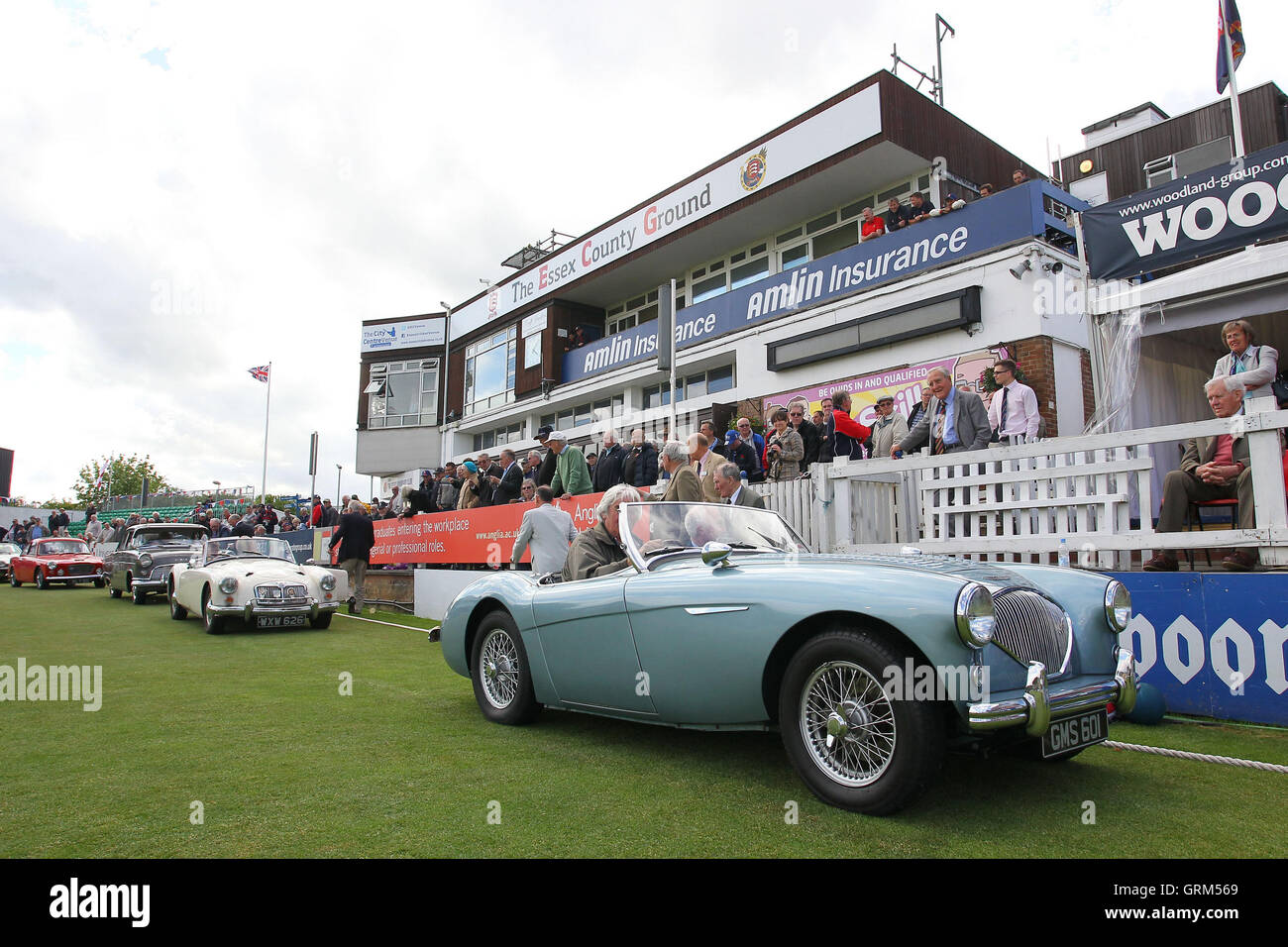A parade of classic cars passes in front of the pavilion during the tea ...