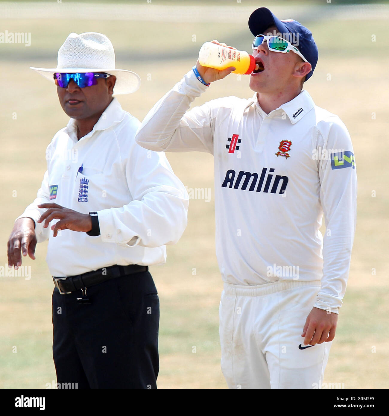 Tom Craddock of Essex (R) takes a drink on a very hot afternoon in ...