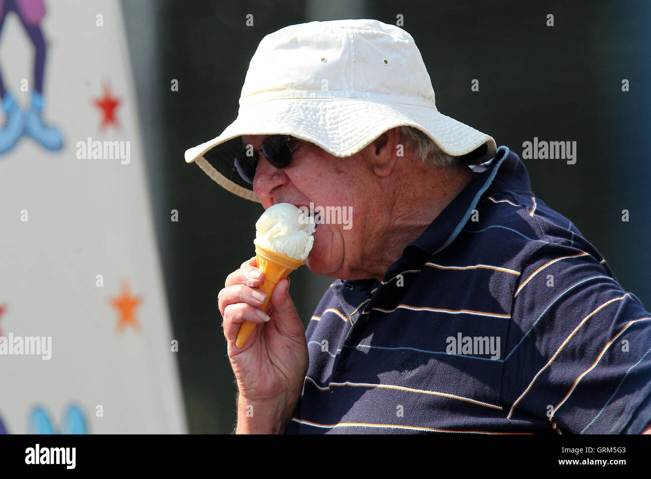 A spectator enjoys an ice cream during the tea interval on a hot day in ...