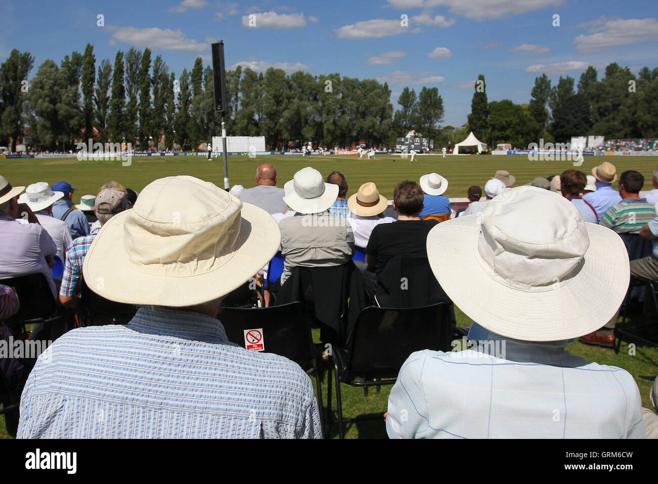 Spectators look on as play progresses on a hot day at Castle Park ...