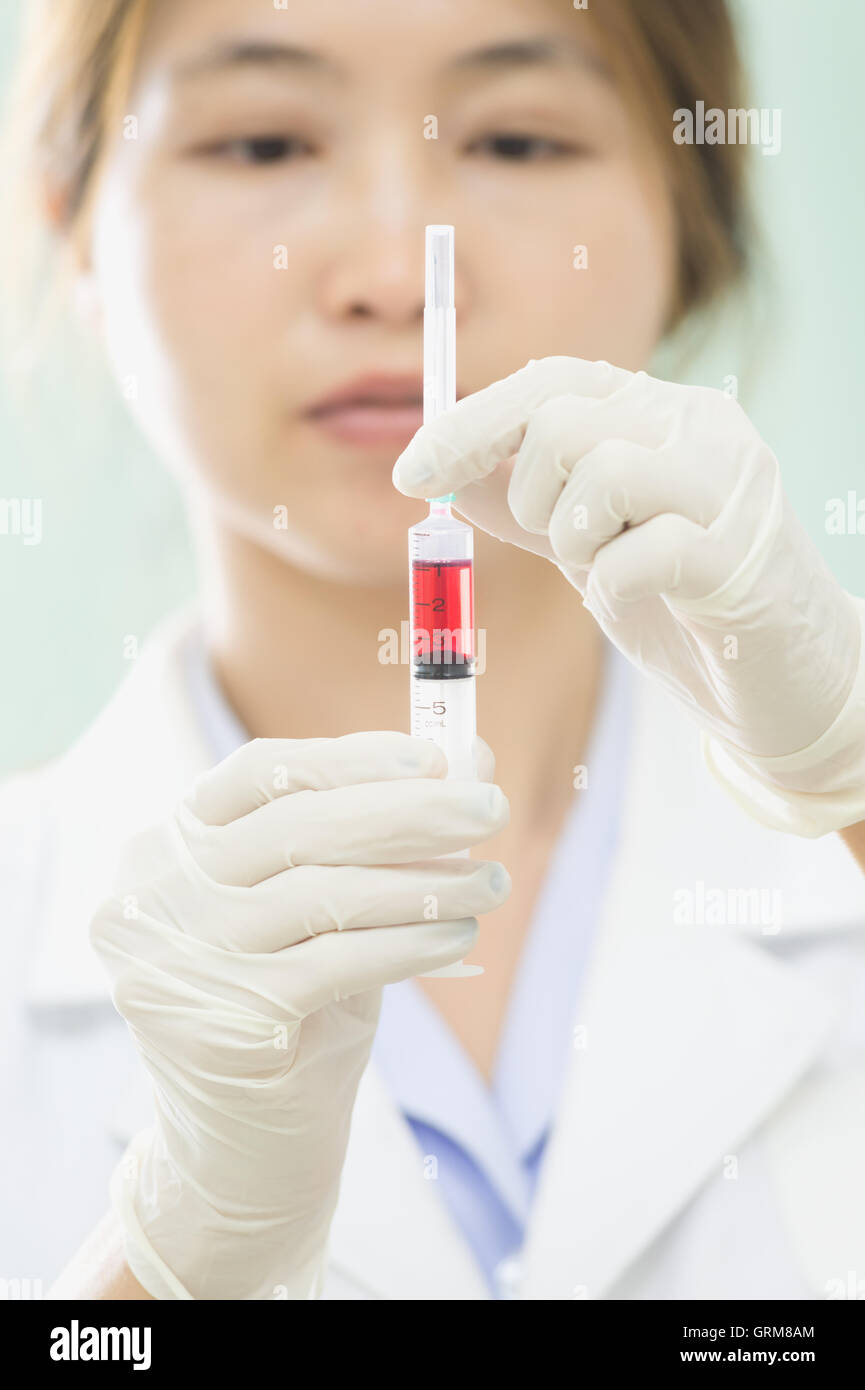 Doctor with red vaccine syringe in hand Stock Photo - Alamy