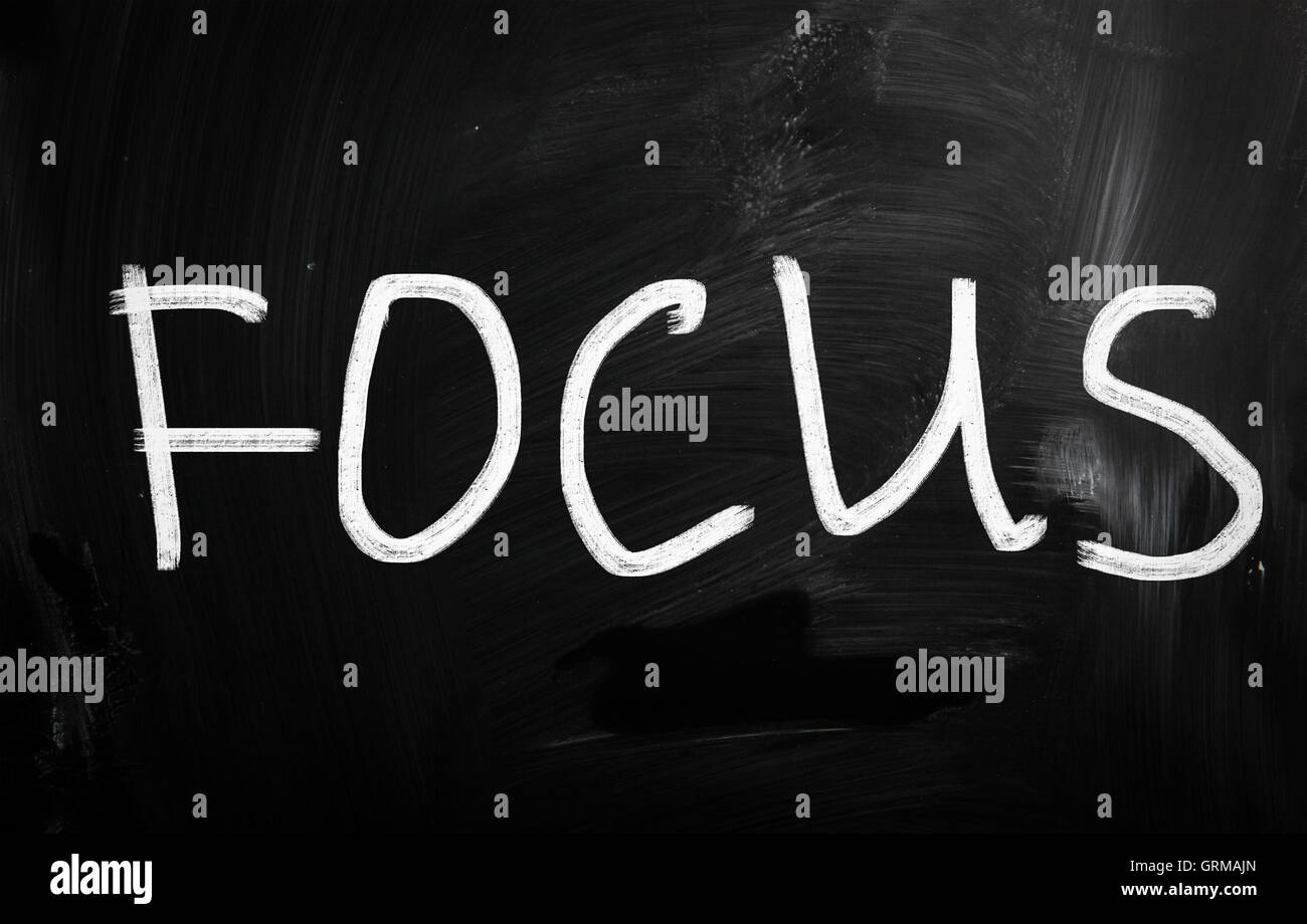The word "Focus" handwritten with white chalk on a blackboard Stock ...