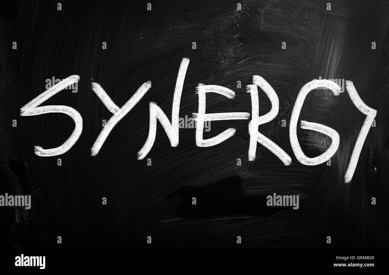 The word "Synergy" handwritten with white chalk on a blackboard Stock ...