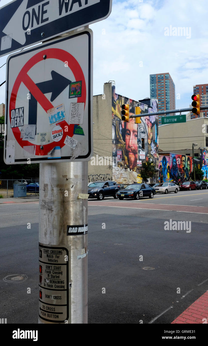 Graffiti and murals on traffic signs and building facade along ...