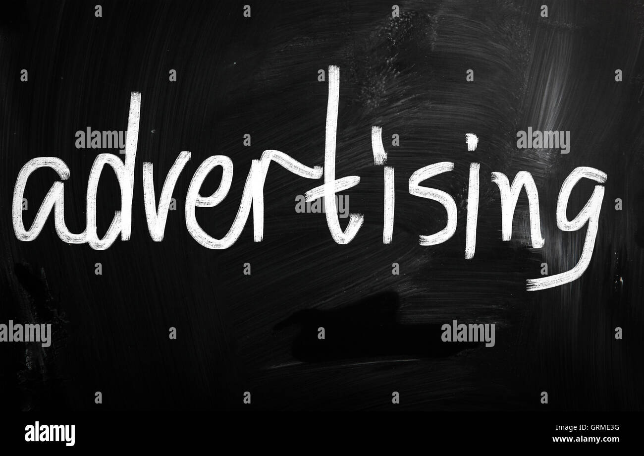 The word "advertising" handwritten with white chalk on a blackbo Stock ...