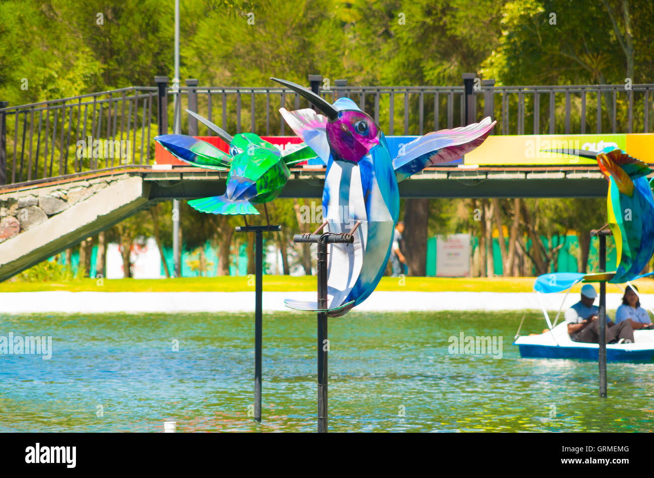 Colorful mockingbird art installation placed on poles inside water ...