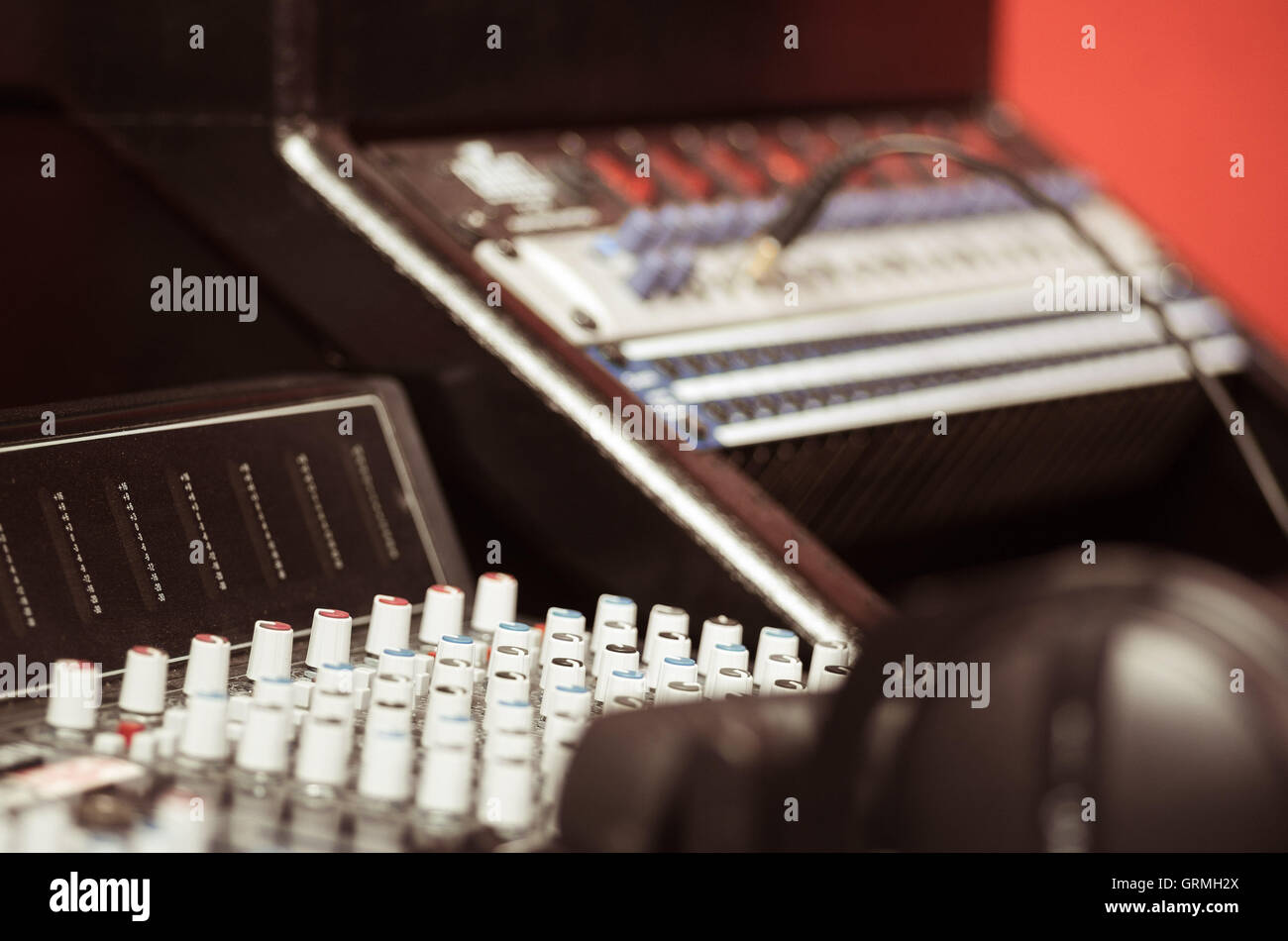 Closeup mixing console with headphones on top, faders and knobs ...