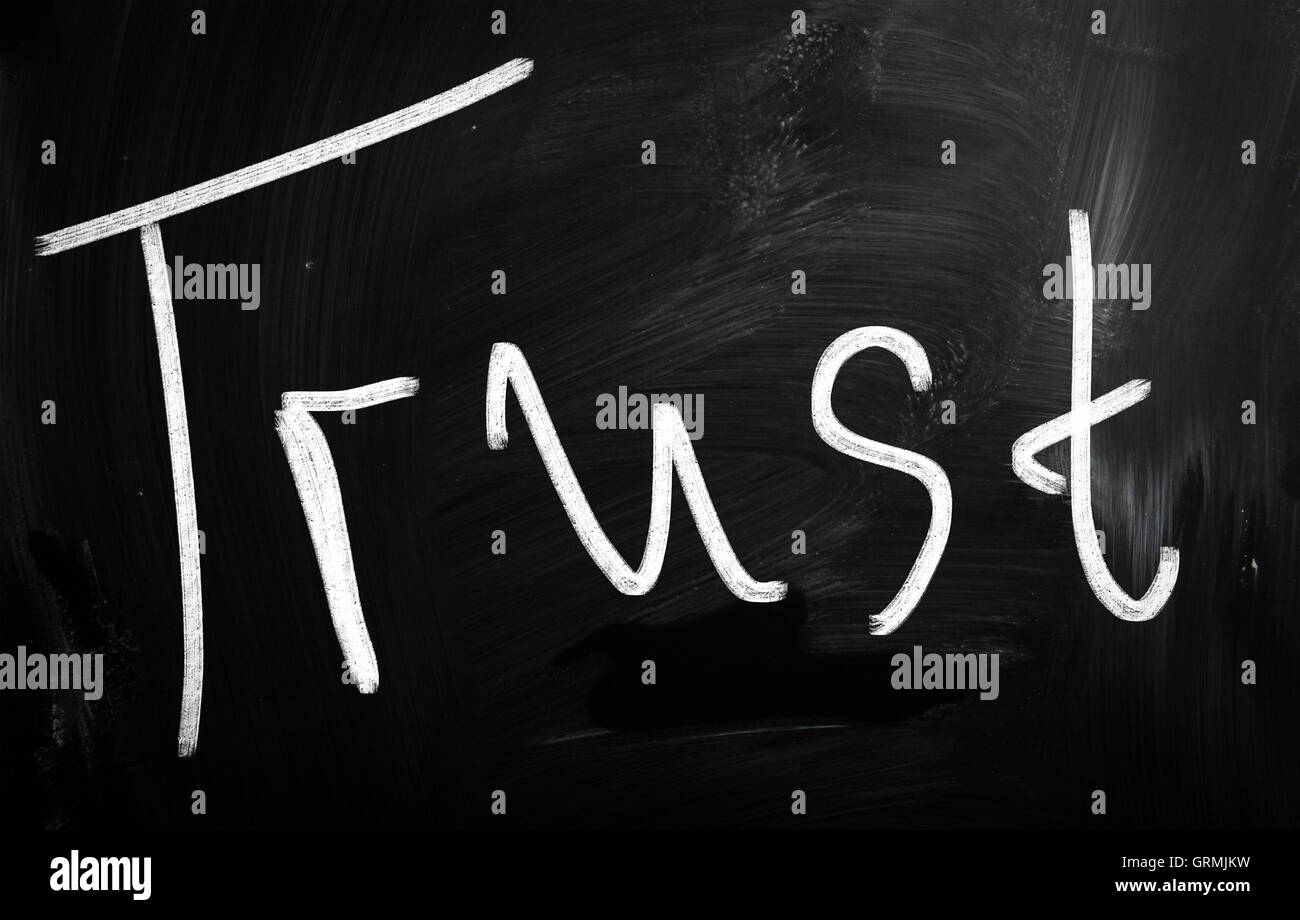 trust written with chalk on blackboard Stock Photo - Alamy