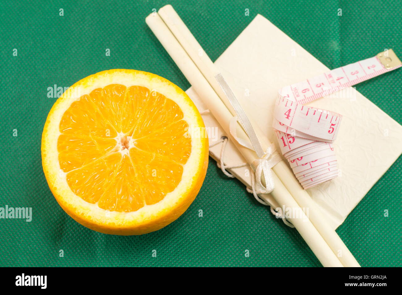 Sliced fresh orange and a body meter on green Stock Photo - Alamy