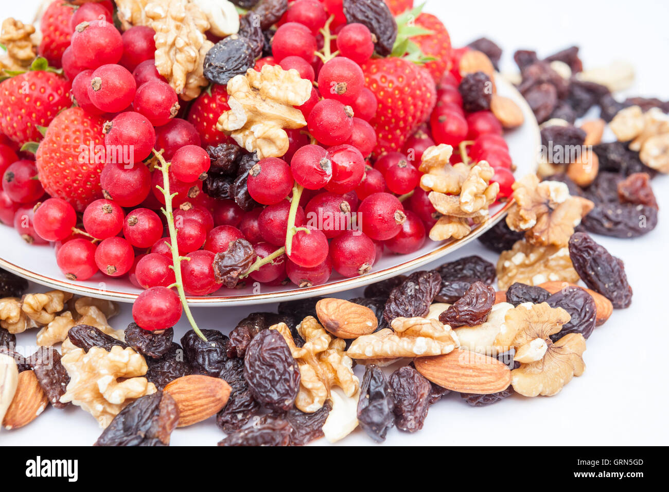 an fruit plate of red berries and strawberry and nuts Stock Photo - Alamy