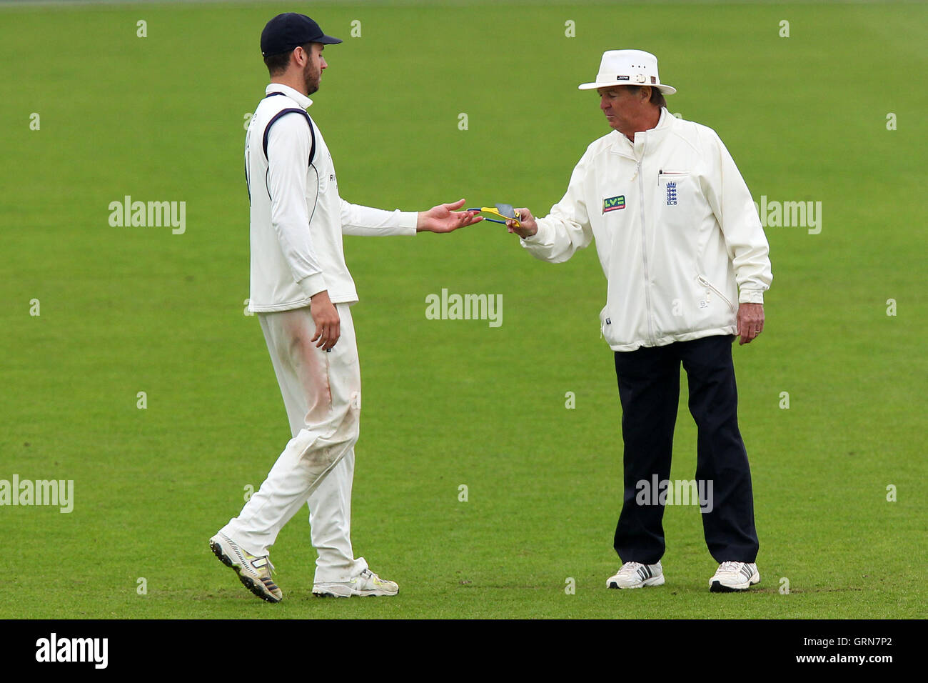 Umpire Trevor Jesty (R) hands James Vince of Hampshire his sunglasses ...