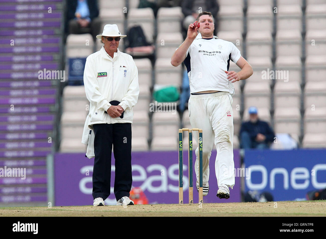 Umpire Trevor Jesty looks on as Matt Coles of Hampshire bowls ...