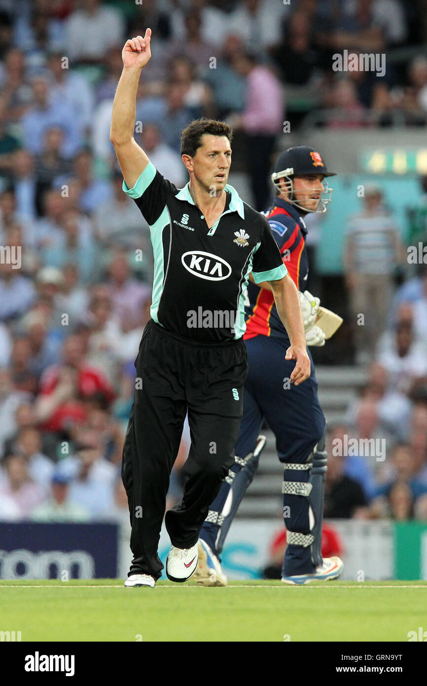 Jon Lewis of Surrey celebrates the wicket of Hamish Rutherford (R ...