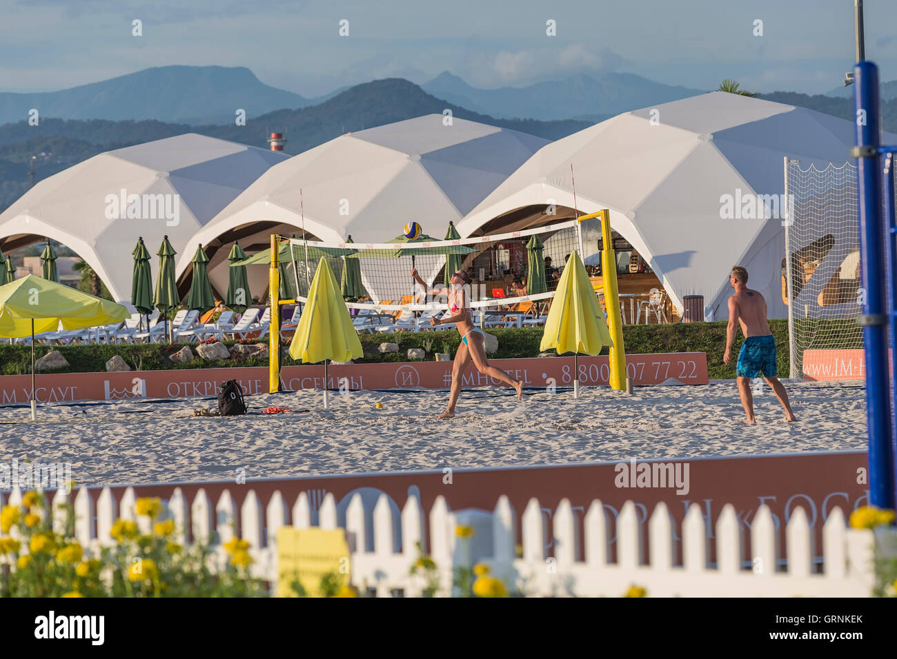 Young people in motion plays in beach volleyball Stock Photo - Alamy