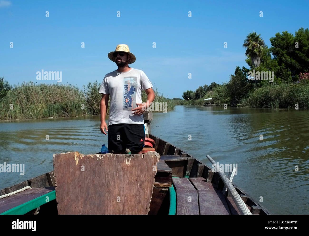 A boatman guides a boat on the Albufera Natural Park lake, in Spain ...