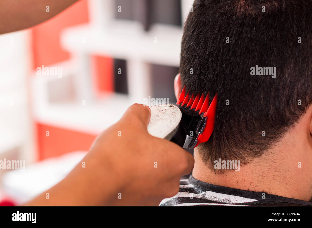 Close up of man hair cut with a machine, red and black tool Stock Photo ...