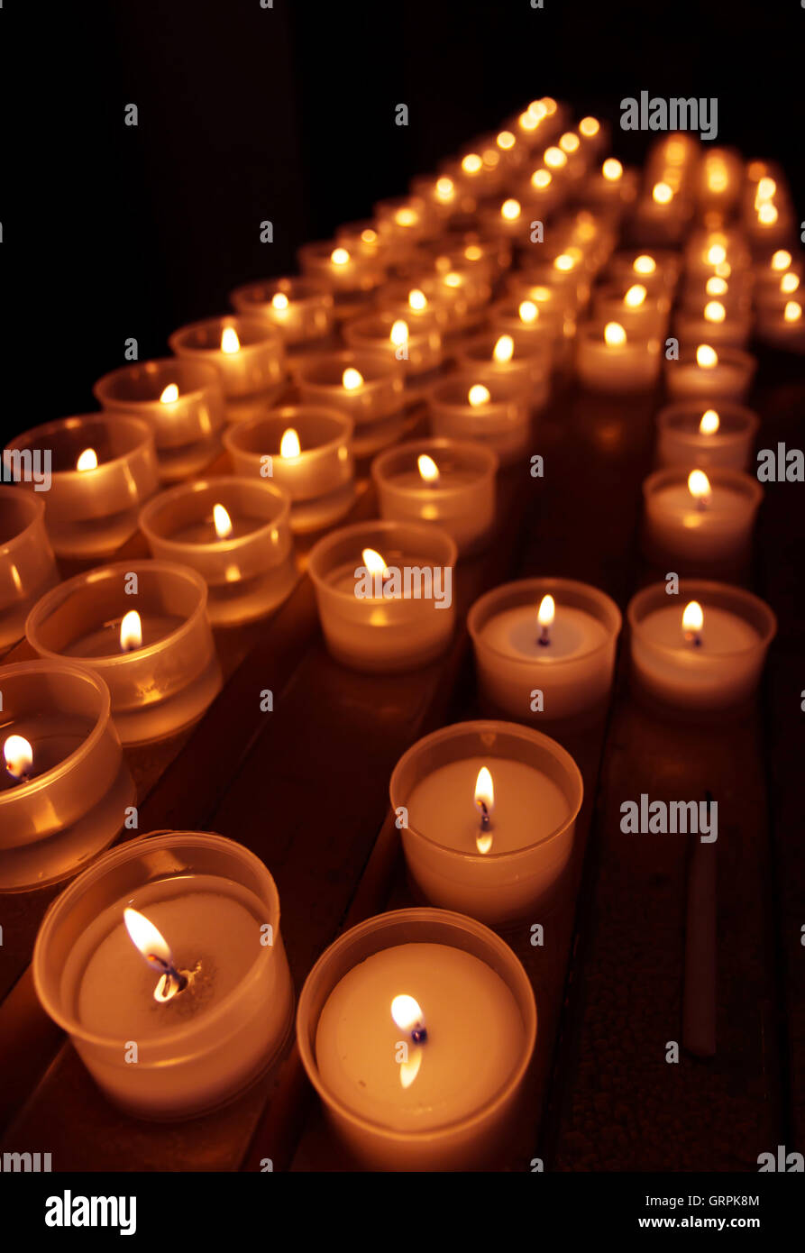 Rows of lit candles in a church Stock Photo - Alamy