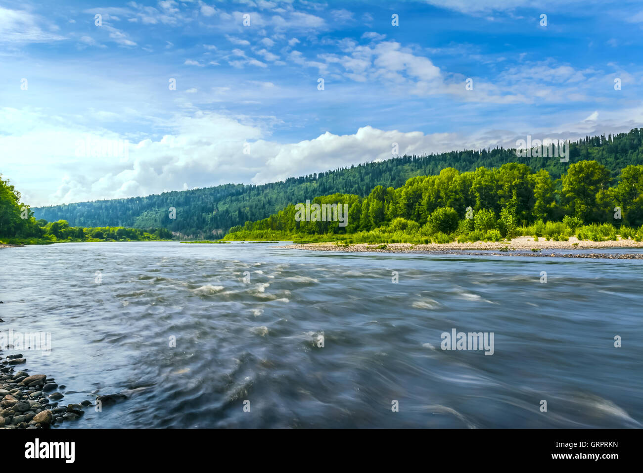 Beautiful river landscape with cloudy blue sky reflected in the clear ...