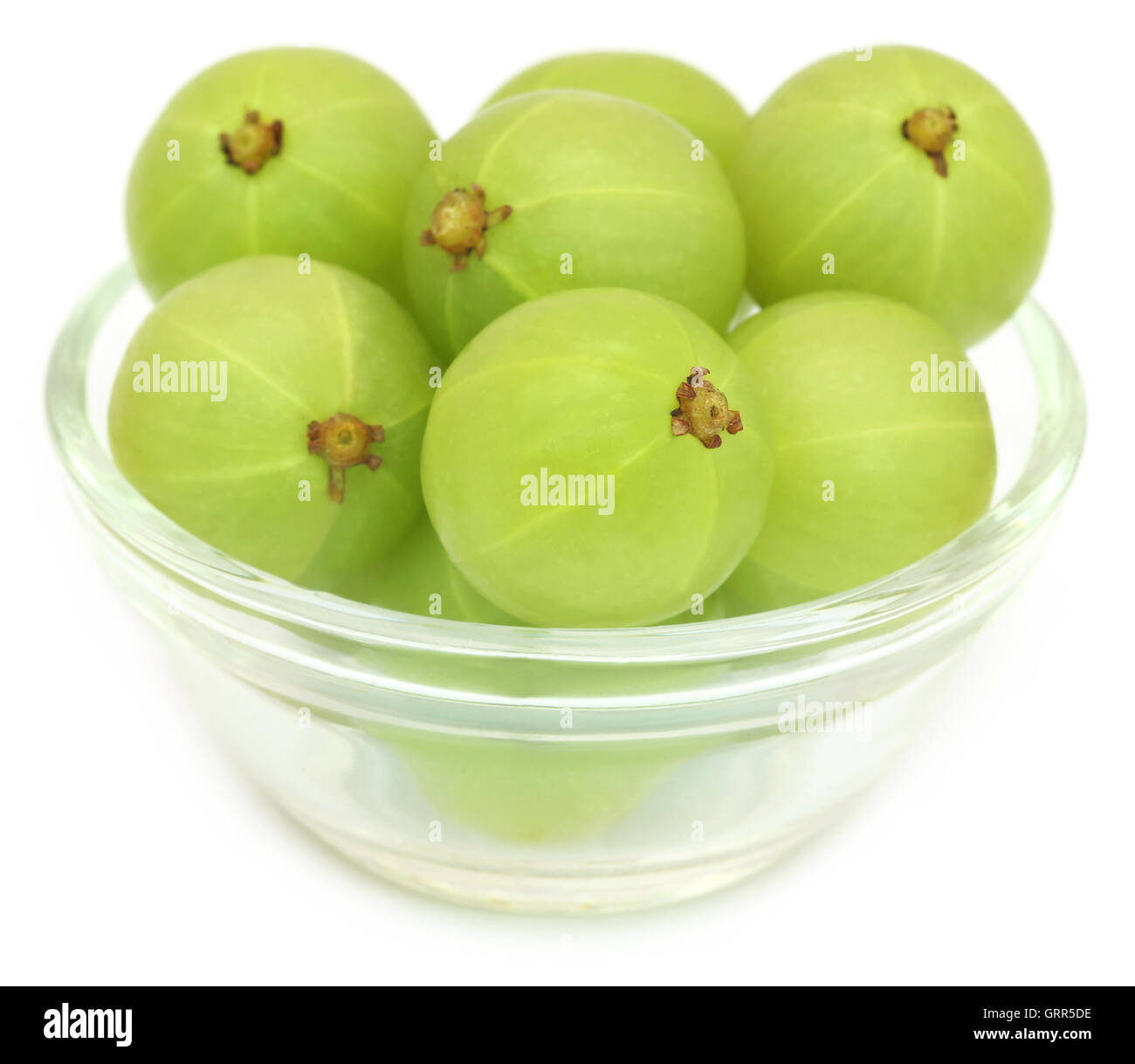 Amla fruits in a glass bowl over white background Stock Photo - Alamy