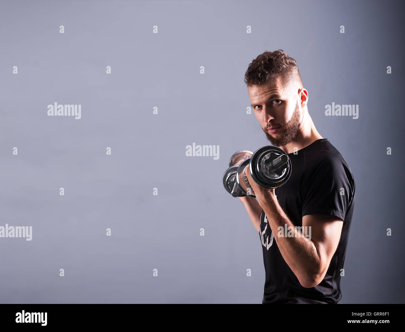 Man raising a dumbbell Copy space Stock Photo - Alamy