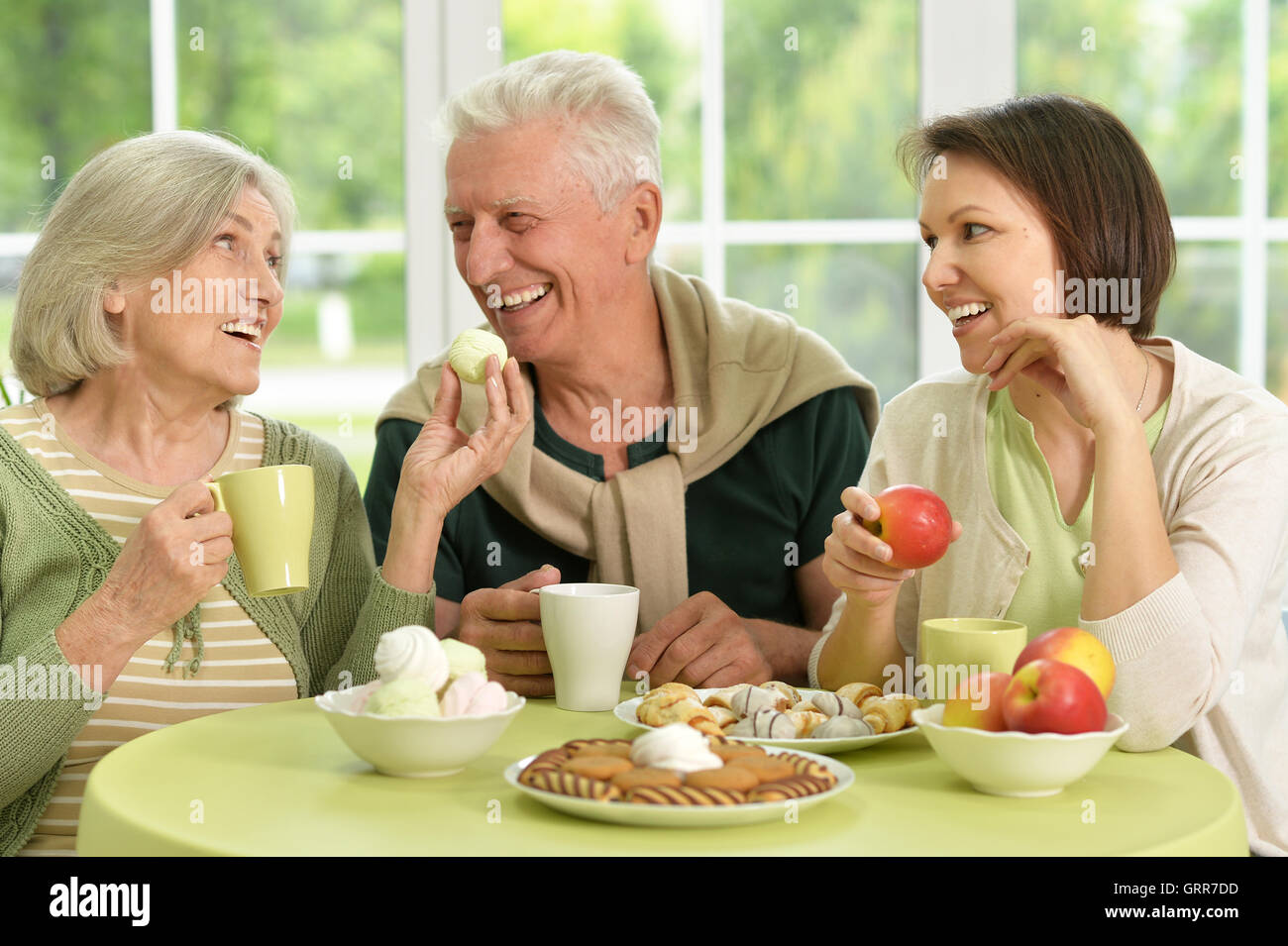 Daughter with senior parents drinking tea Stock Photo - Alamy