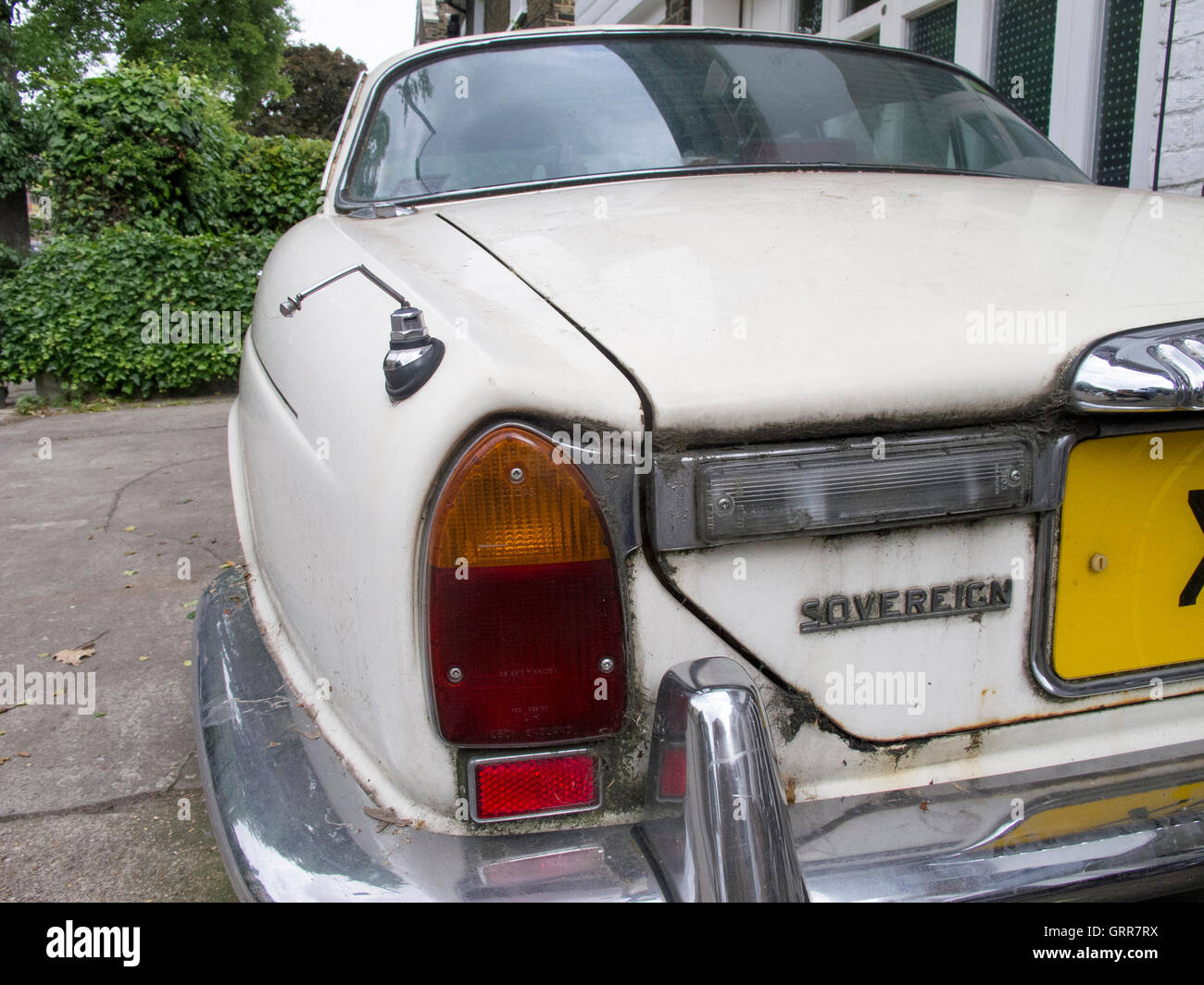 An old classic Jaguar car looking slightly worse for wear on a city ...